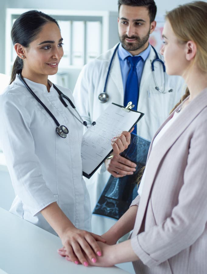 Handsome Doctor is Talking with Young Female Patient and Making Notes ...