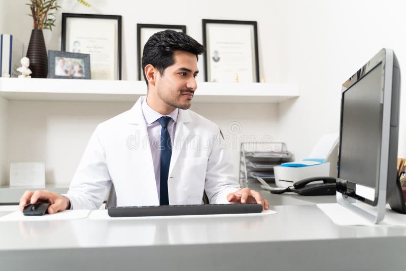 Handsome Doctor Working at Desk in Office Stock Photo - Image of ...