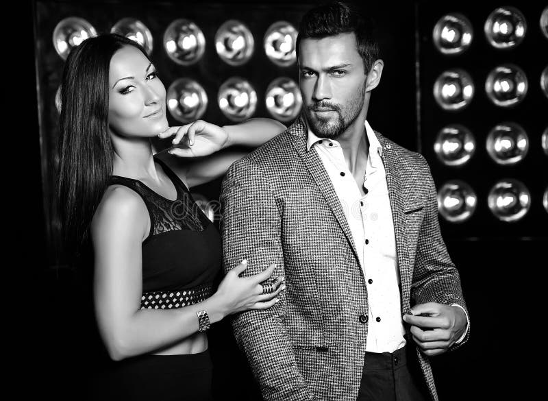 Handsome Elegant Man In Suit With Beautiful Woman Posing On Black