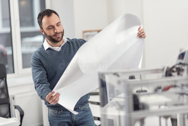 Handsome Engineer Examining Blueprint in His Hands Stock Image - Image ...