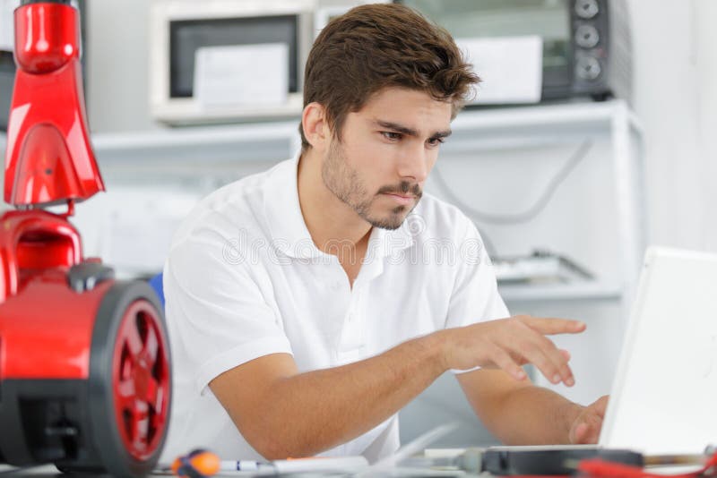 Handsome Engineer Researching Manufacturing Issues with Vacuum Cleaner ...