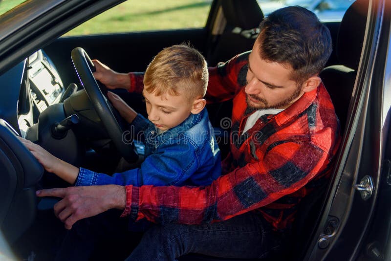 Handsome Father Pointing On Something While Teaching Teen Son Driving
