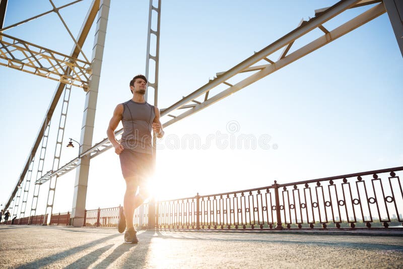 Handsome Fit Man Running Fast Along Big Modern Bridge Stock Photo ...