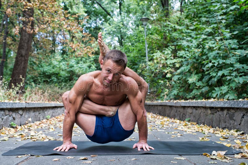 Handsome Flexible Athletic Man Doing Yoga Asanas in the Park Stock ...
