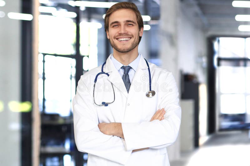 Handsome Friendly Young Doctor on Hospital Corridor Looking at Camera ...