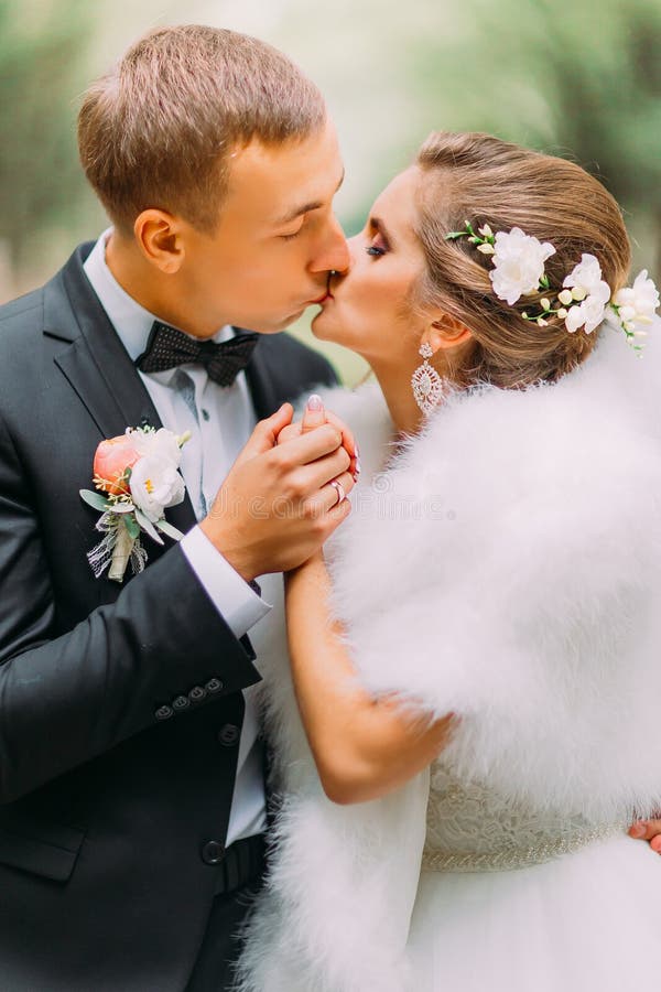 Handsome Groom Sensual Kisses His Attractive Happy Bride Outdoors