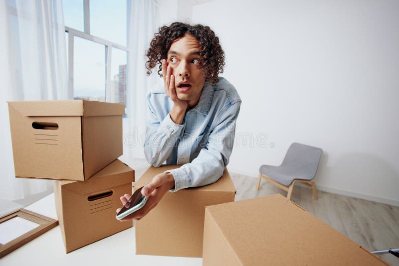 Handsome Guy Cardboard Boxes in the Room Unpacking with Phone Sorting ...