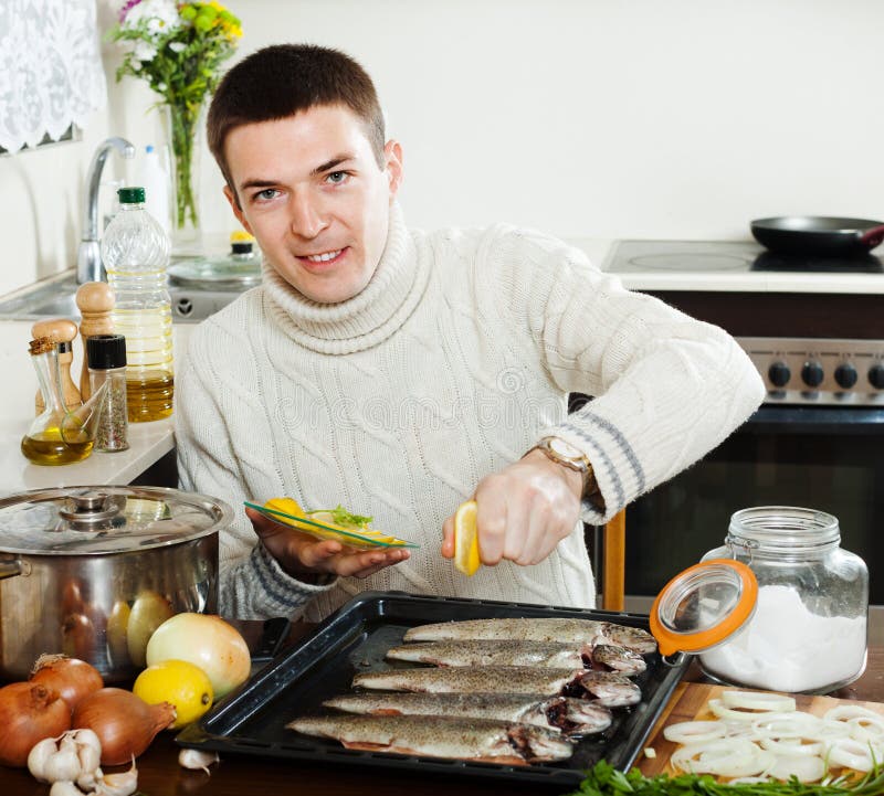 Handsome Guy Cooking Raw Fish With Lemon Stock Image - Image of happy ...