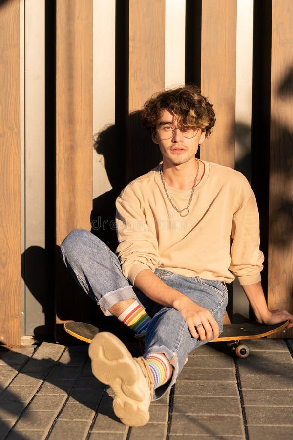 Handsome Guy in Jeans and Sweatshirt Sitting by Wall Stock Photo ... Handsome Guy in Jeans and Sweatshirt Sitting by Wall Stock Photo ...