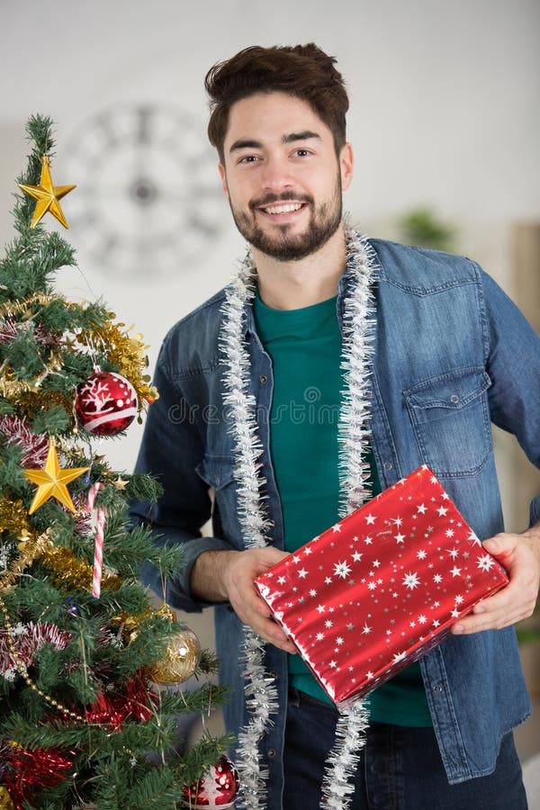 Handsome Guy Putting Christmas Present Under Tree Stock Photo - Image ...