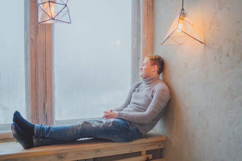 Handsome Guy Sitting on the Windowsill on the Background of a Large ...