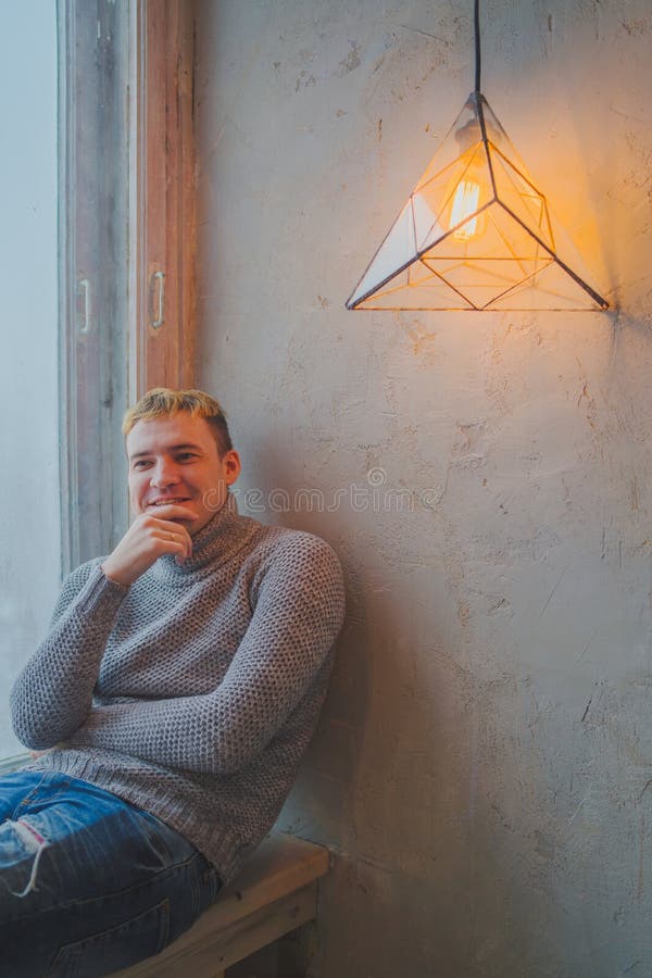 Handsome Guy Sitting on the Windowsill on the Background of a Large ...