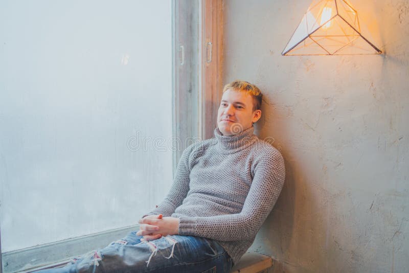 Handsome Guy Sitting on the Windowsill on the Background of a Large ...