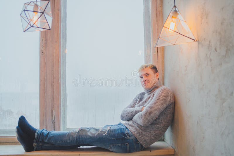 Handsome Guy Sitting on the Windowsill on the Background of a Large ...
