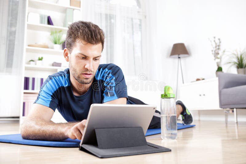 Handsome Guy with Tablet Computer Lying on a Mat Stock Photo - Image of ...