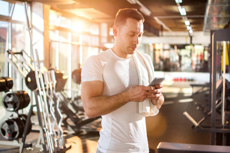 Handsome Guy Text Messaging on His Smartphone at Gym. Stock Photo ...