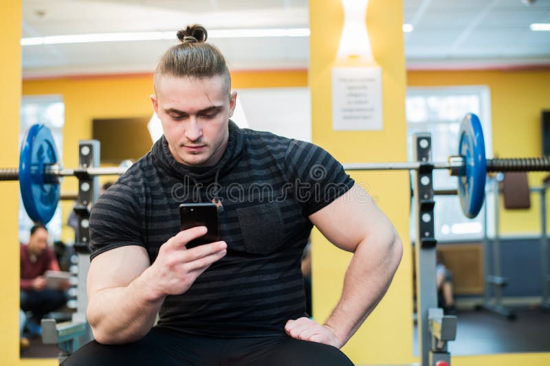 Handsome Guy Text Messaging on His Smartphone at Gym. Stock Photo ...