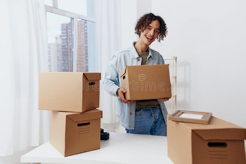 Handsome Guy Unpacking with Box in Hand Sorting Things Out Stock Photo ...