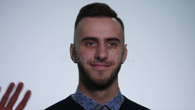 Handsome Guy Waving His Hand and Looking at the Camera Stock Video ...