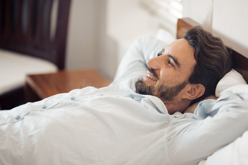 Handsome Happy Man Lying on Bed. Stock Photo - Image of handsome ...