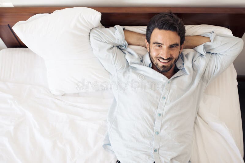 Handsome Happy Man Lying on Bed in Bedroom. Stock Photo - Image of ...