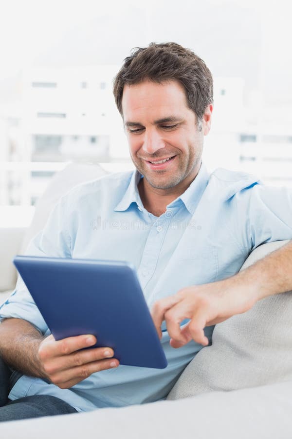 Handsome Happy Man Sitting on the Sofa Using His Tablet Pc Stock Image ...