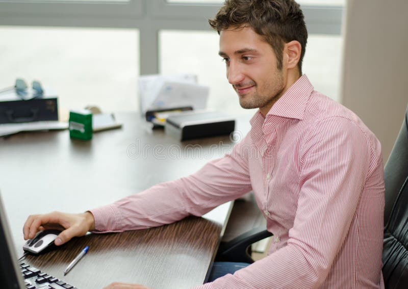 Handsome, Happy Office Worker Smiling while Using Computer Stock Image ...