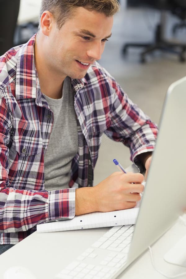 Handsome Happy Student Using Computer Taking Notes Stock Photo - Image ...