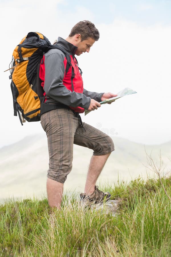 Handsome Hiker with Backpack Walking Uphill Reading a Map Stock Image ...