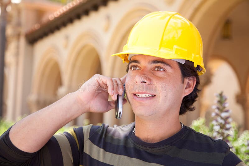 Handsome Hispanic Contractor on Phone with Hard Hat Outside Stock Image ...