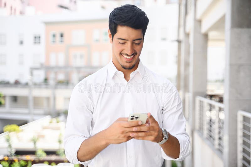 Handsome Hispanic Guy is Using Smartphone for Messaging, Texting Stock ...