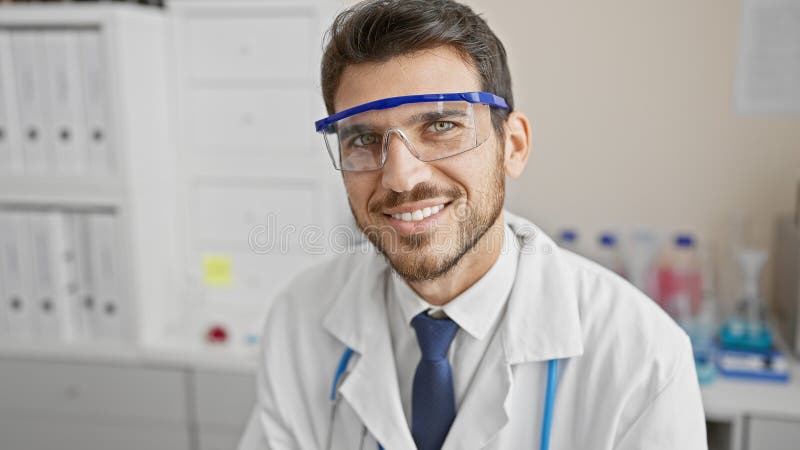 Handsome Hispanic Man with Beard in Lab Coat and Safety Glasses Inside ...