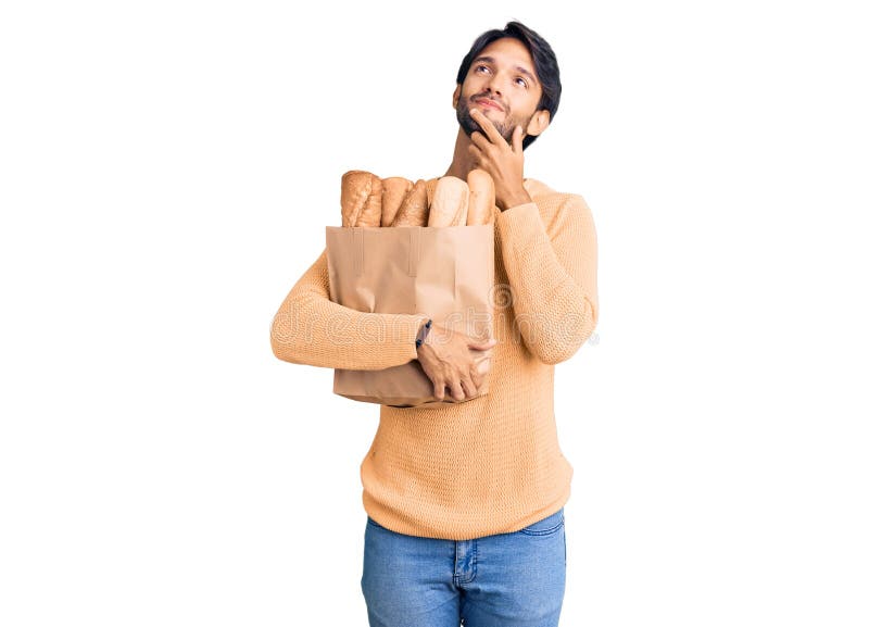 Handsome Hispanic Man Holding Paper Bag with Bread Serious Face ...