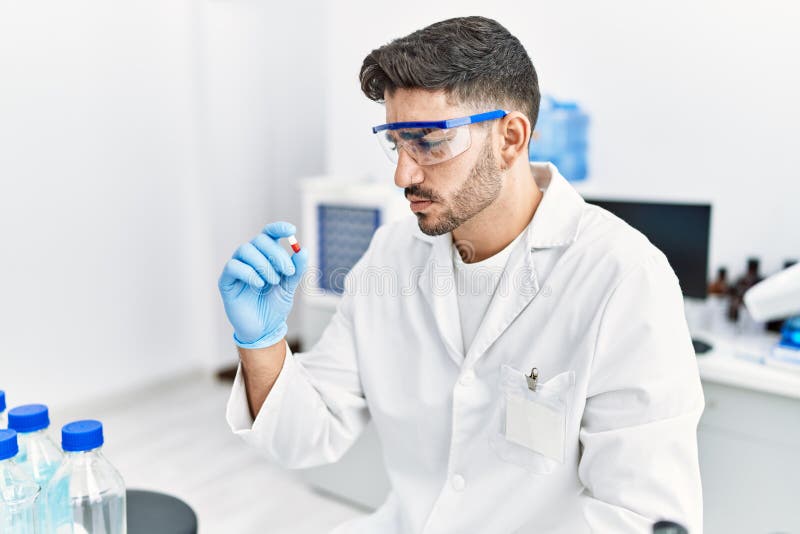 Handsome Hispanic Man Holding Pharmaceutical Pill at Laboratory Stock ...