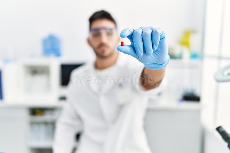 Handsome Hispanic Man Holding Pharmaceutical Pill at Laboratory Stock ...