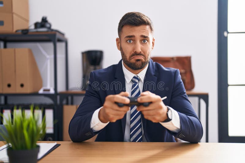 Handsome Hispanic Man Playing Video Games at the Office Depressed and ...