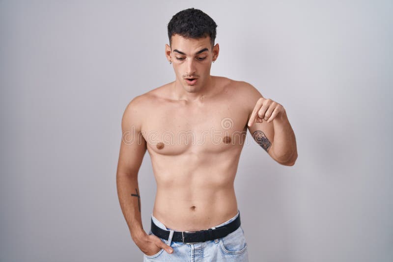 Handsome Hispanic Man Standing Shirtless Pointing Down With Fingers