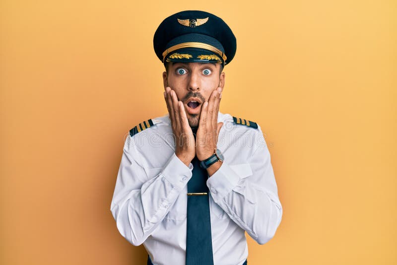 Handsome Hispanic Man Wearing Airplane Pilot Uniform Afraid and Shocked ...