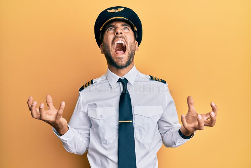 Handsome Hispanic Man Wearing Airplane Pilot Uniform Crazy and Mad ...
