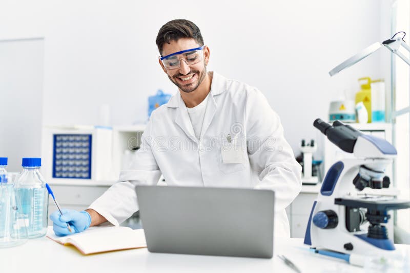 Handsome Hispanic Man Working As Scientific with Microscope and Laptop ...