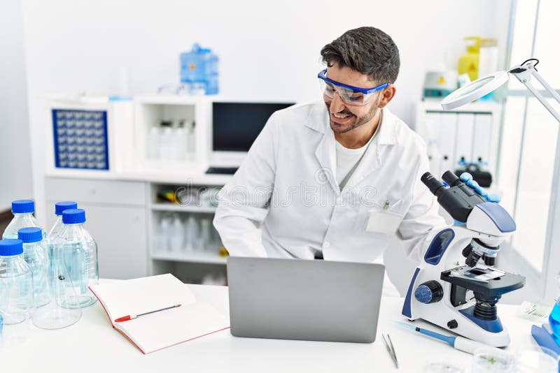 Handsome Hispanic Man Working As Scientific with Microscope and Laptop ...