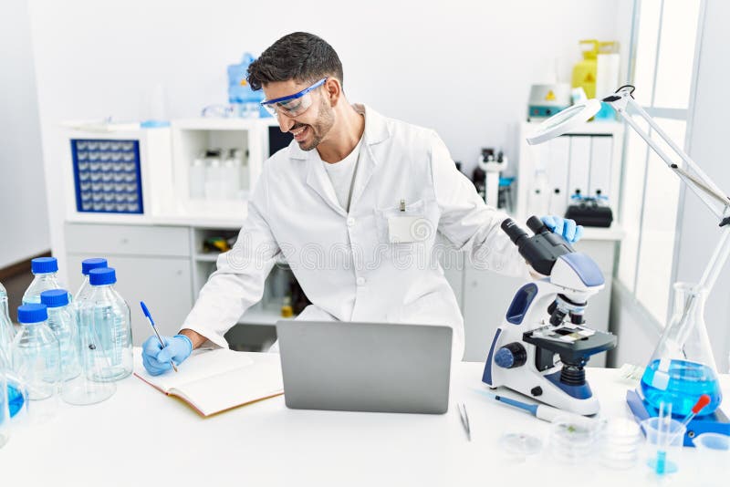 Handsome Hispanic Man Working As Scientific with Microscope and Laptop ...