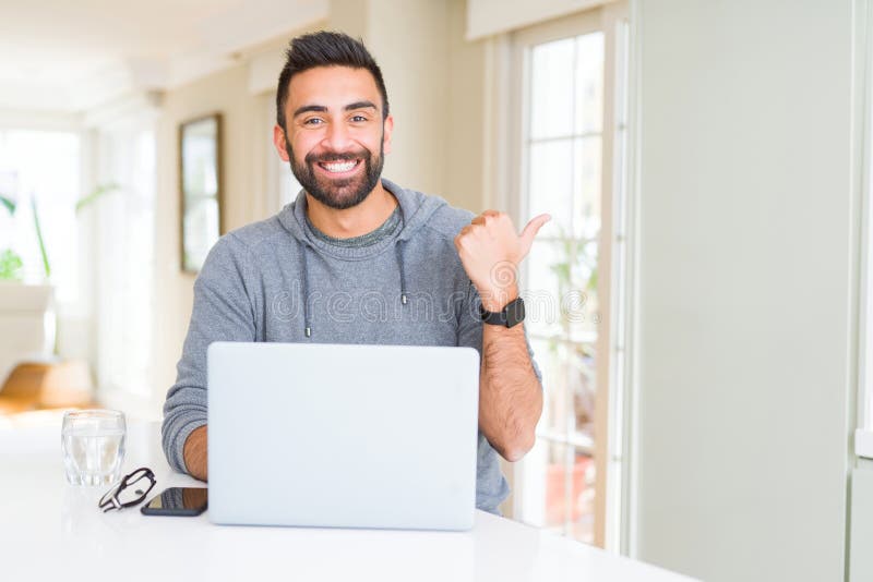 Handsome Hispanic Man Working Using Computer Laptop Pointing and ...