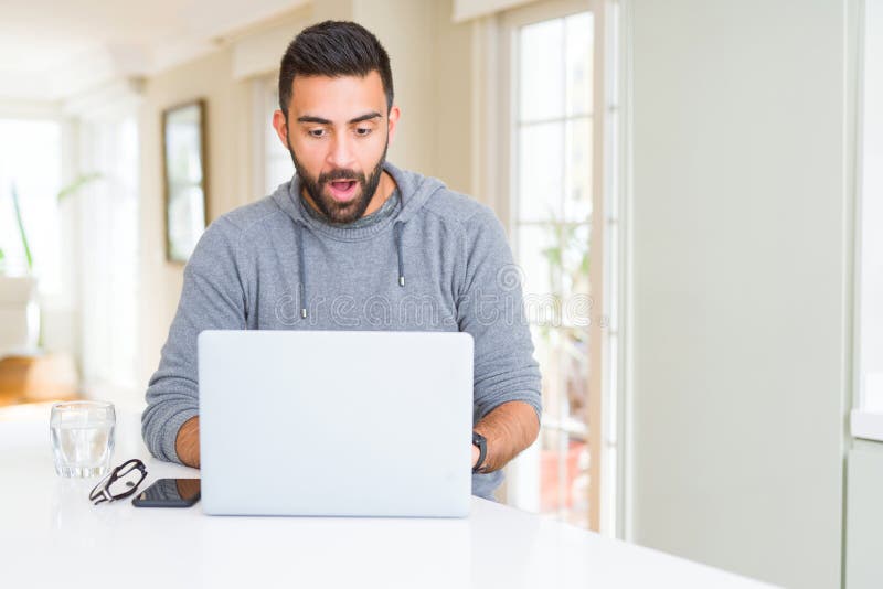 Handsome Hispanic Man Working Using Computer Laptop Scared in Shock ...