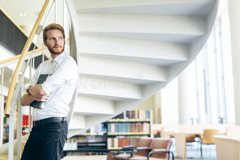 Handsome Intelligent Guy Reading a Book in a Library Stock Photo ...