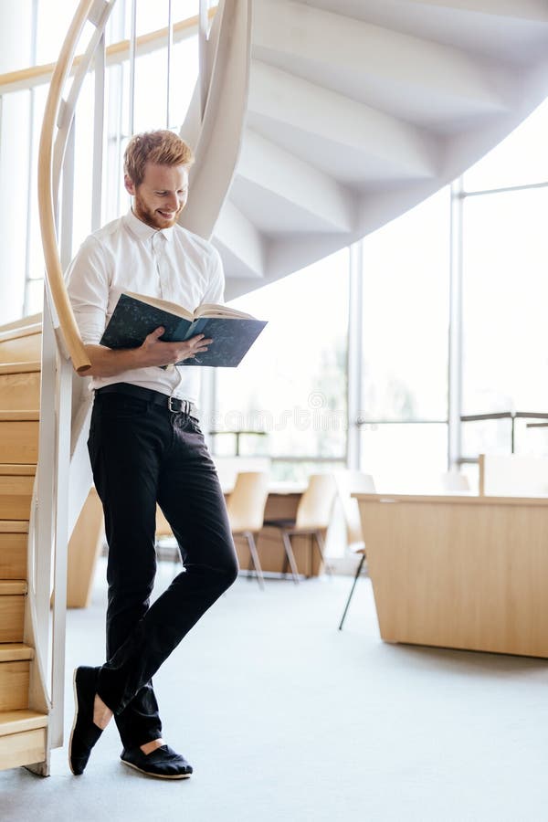 Handsome Intelligent Guy Reading a Book in a Library Stock Photo ...