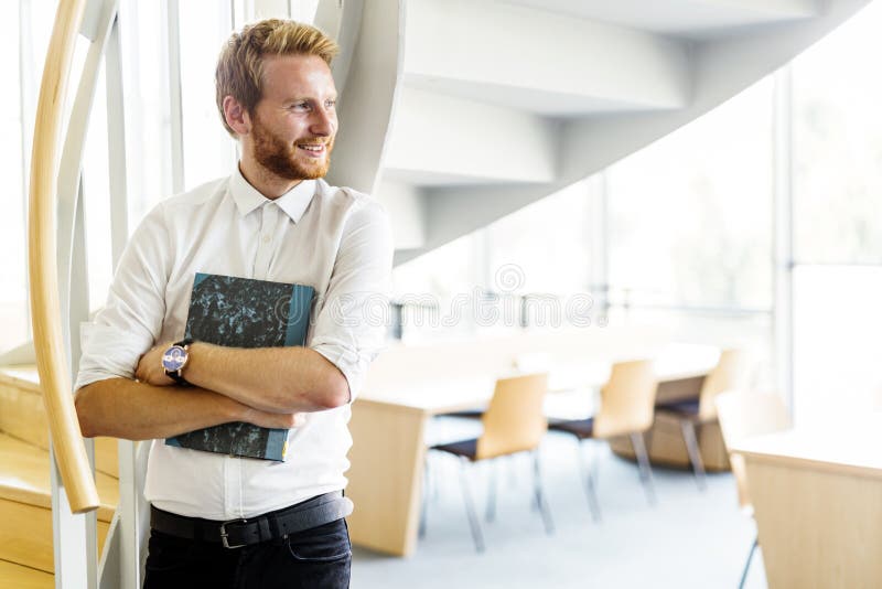 Handsome Intelligent Guy Reading a Book in a Library Stock Photo ...