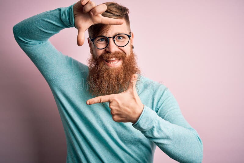 Handsome Irish Redhead Man With Beard Wearing Glasses Over Pink