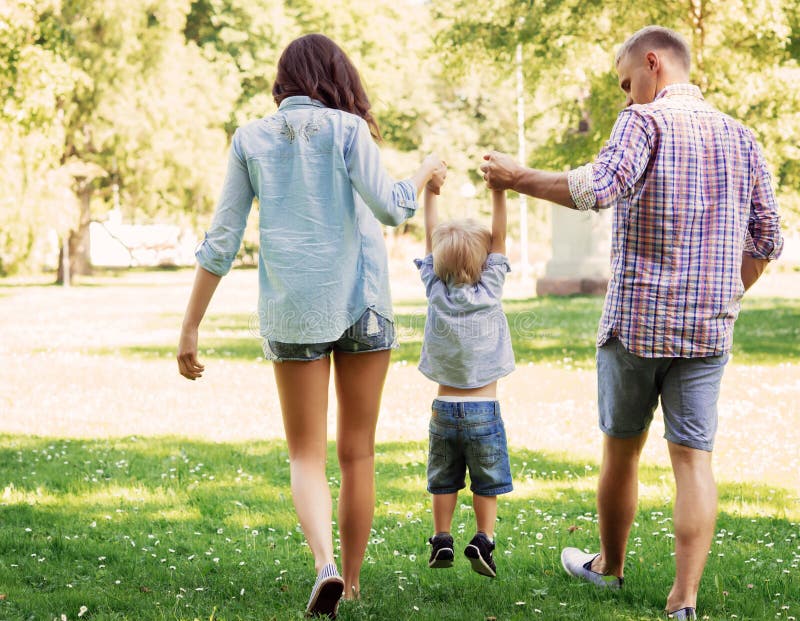 Handsome Toddler Having a Walk with Parents Holding Their Hands Stock ...