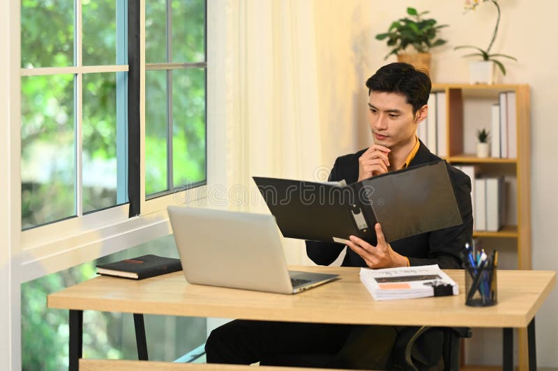 Handsome Male Account Manager Checking Reports at His Office Desk Stock ...